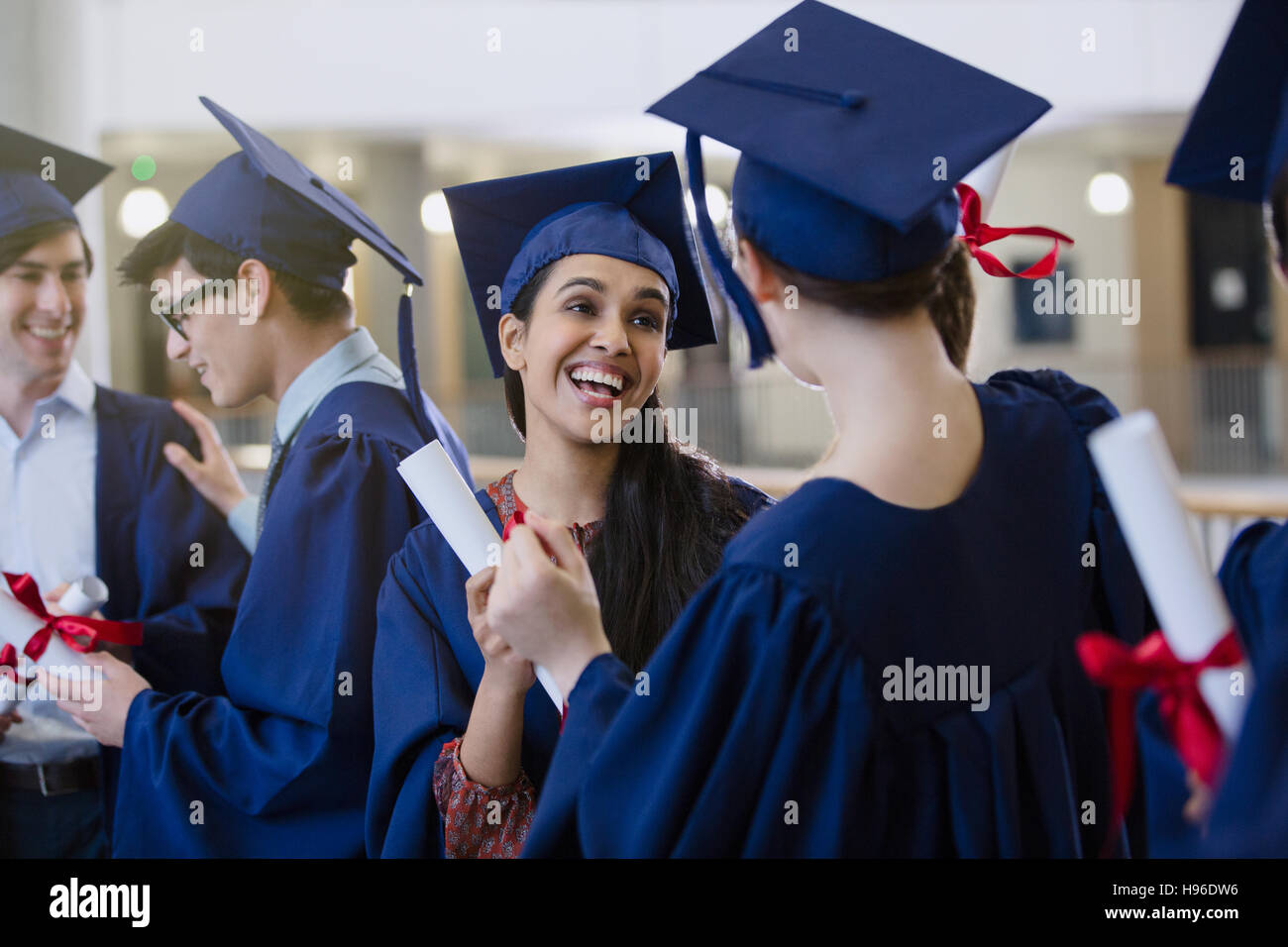 Happy female college student graduates with cap and gown and diplomas ...