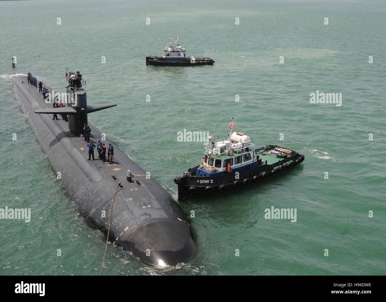 A tug boat guides the USN Los Angeles-class fast-attack submarine USS ...