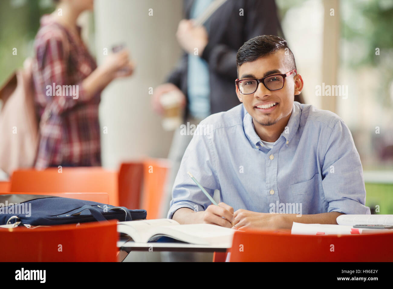 Portrait confident male college student studying in library Stock Photo ...