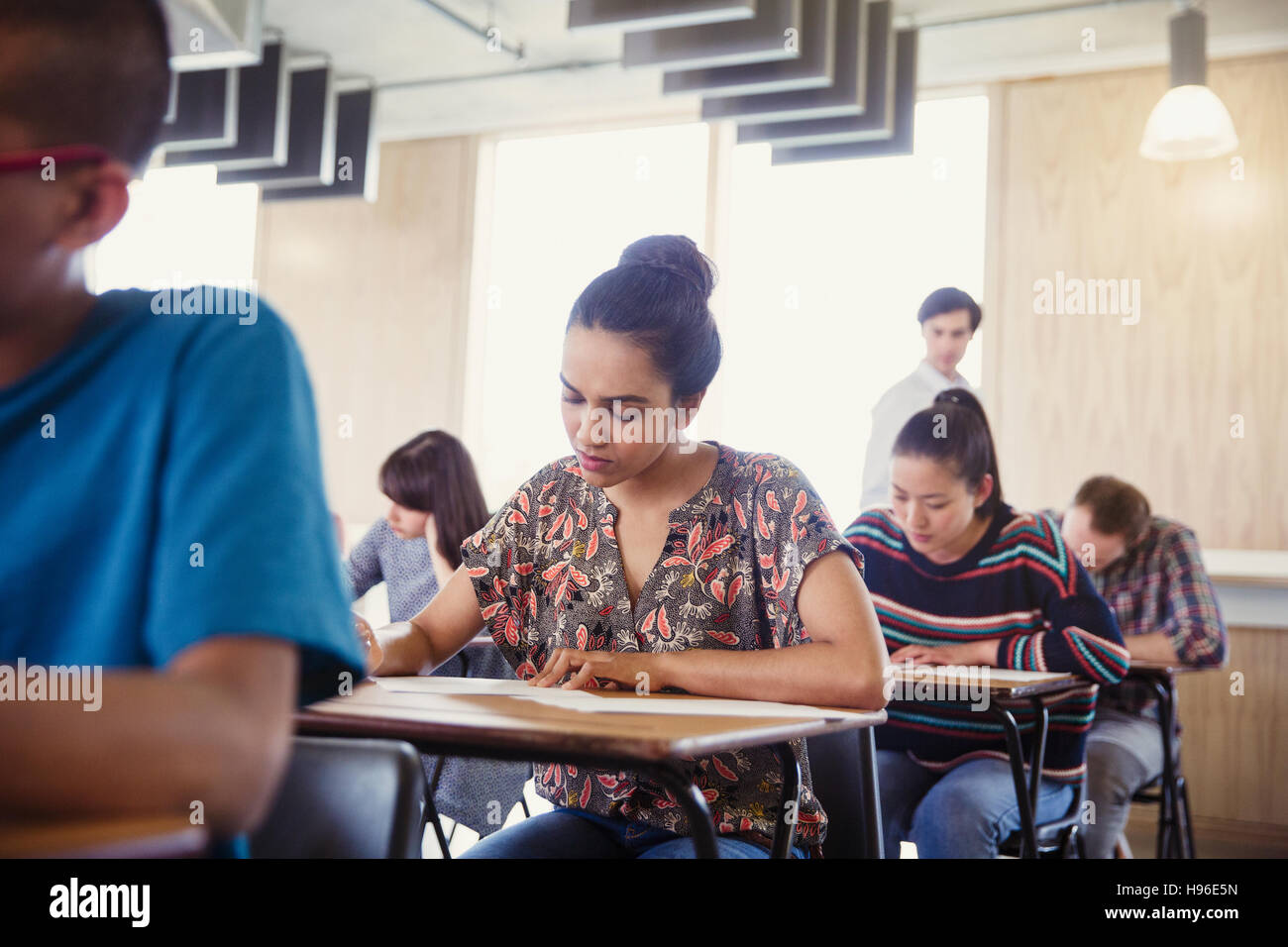 Female college student taking test at desk in classroom Stock Photo - Alamy