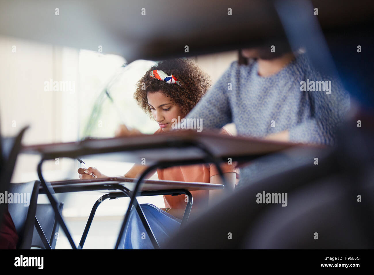 Female college student taking test at desk in classroom Stock Photo - Alamy