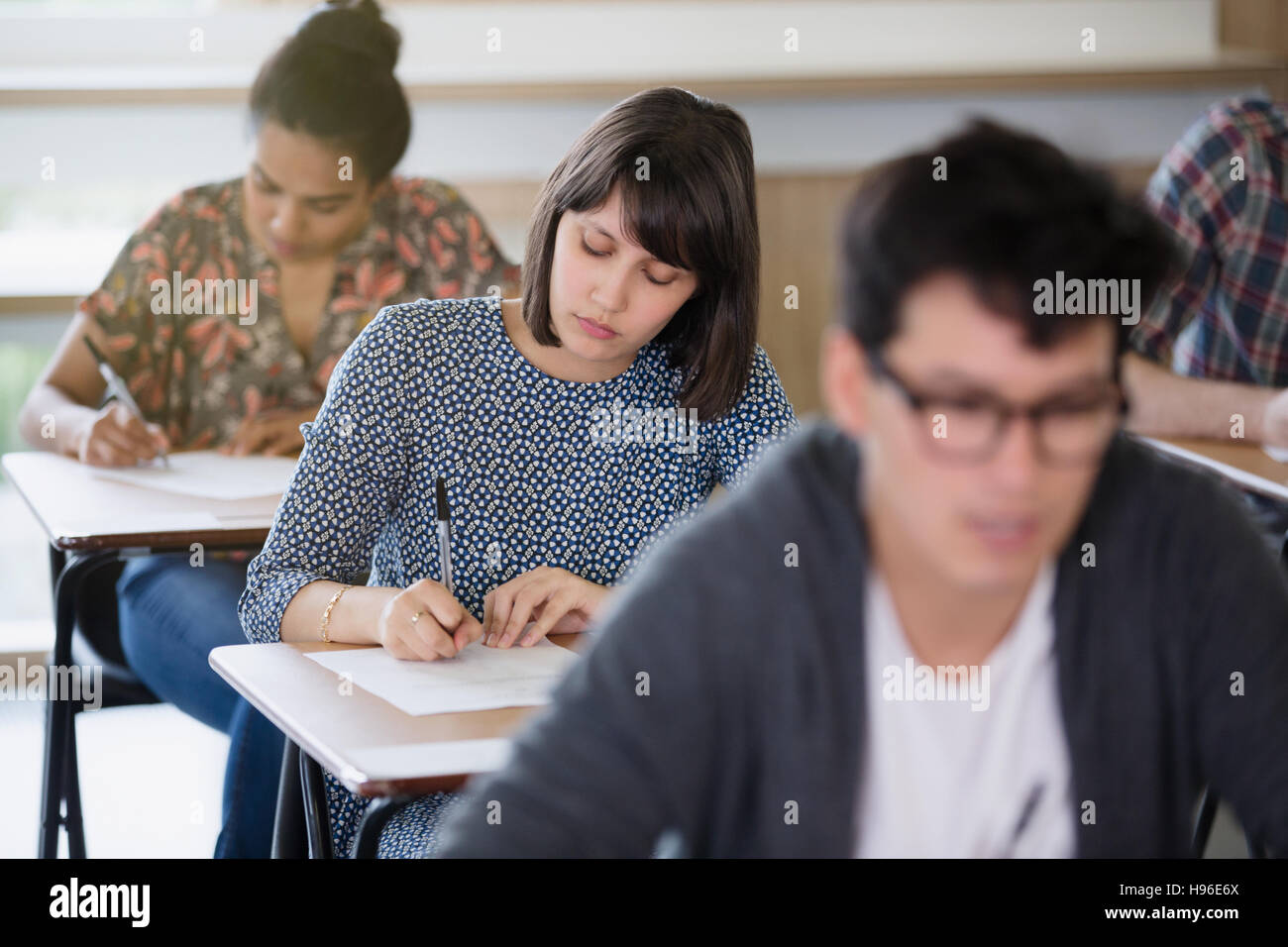 Female college student taking test at desk in classroom Stock Photo - Alamy