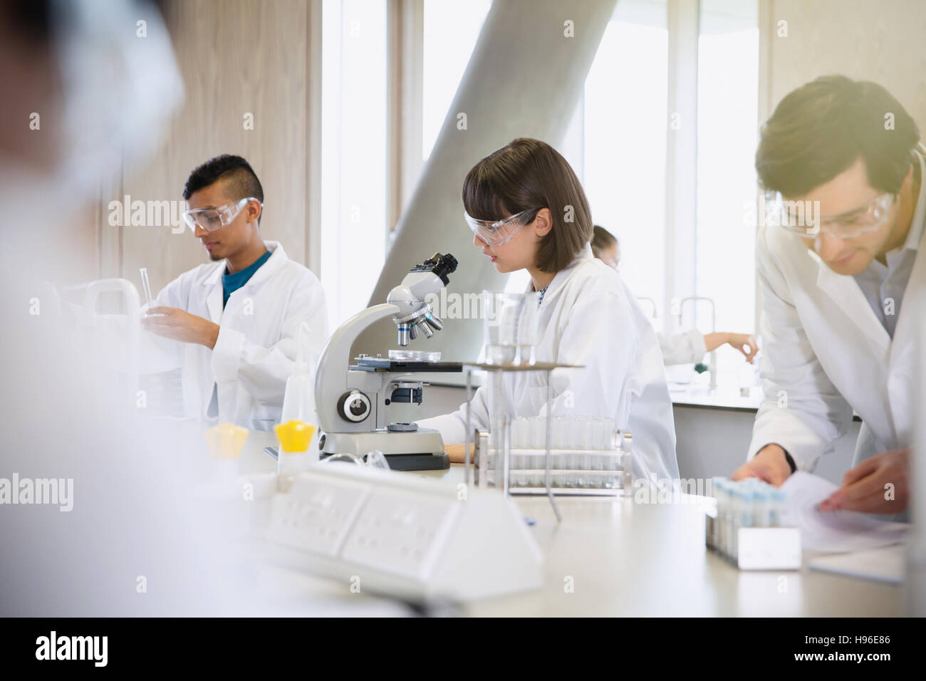 College students conducting scientific experiment in science laboratory ...