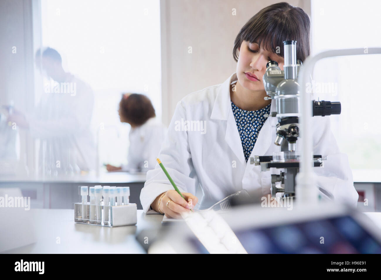 Female college student conducting scientific experiment in science ...