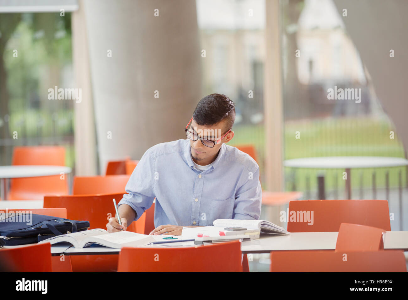 Male college student studying at table Stock Photo - Alamy