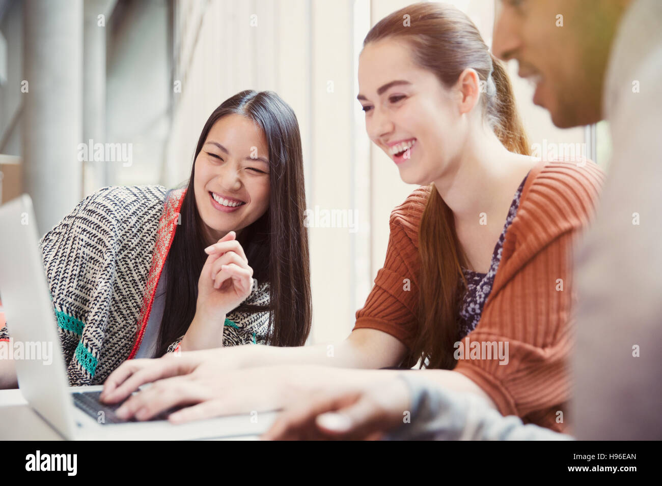 Smiling college students using laptop Stock Photo - Alamy