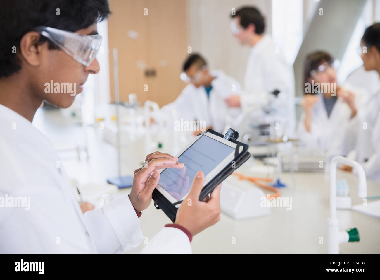 Male college student using digital tablet in science laboratory ...