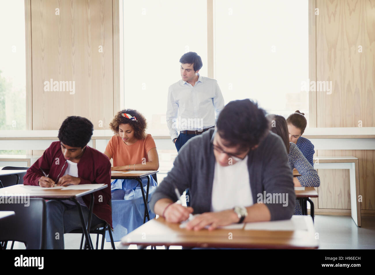 Professor watching college students taking test in classroom Stock ...