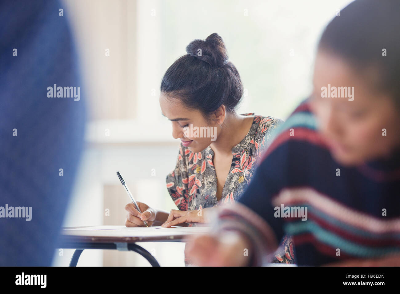 Female college student taking test at desk in classroom Stock Photo - Alamy