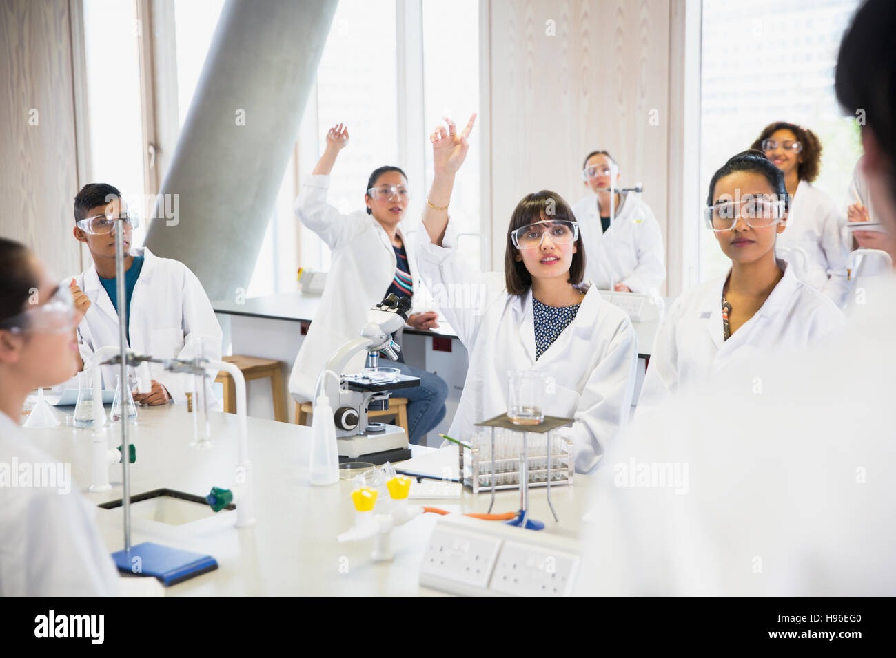 College students raising hands in science laboratory classroom Stock ...
