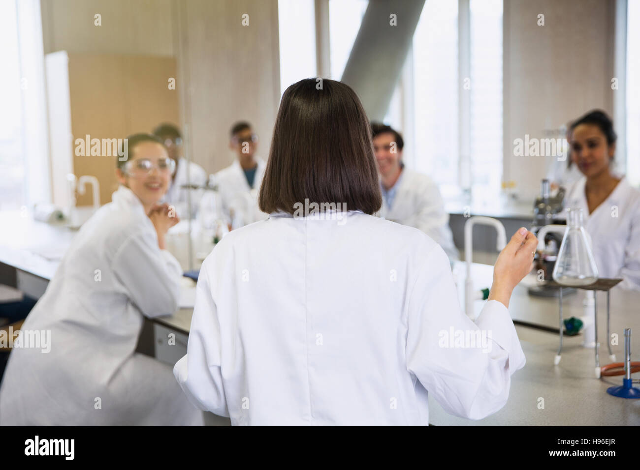 Female college student leading study group in science laboratory ...