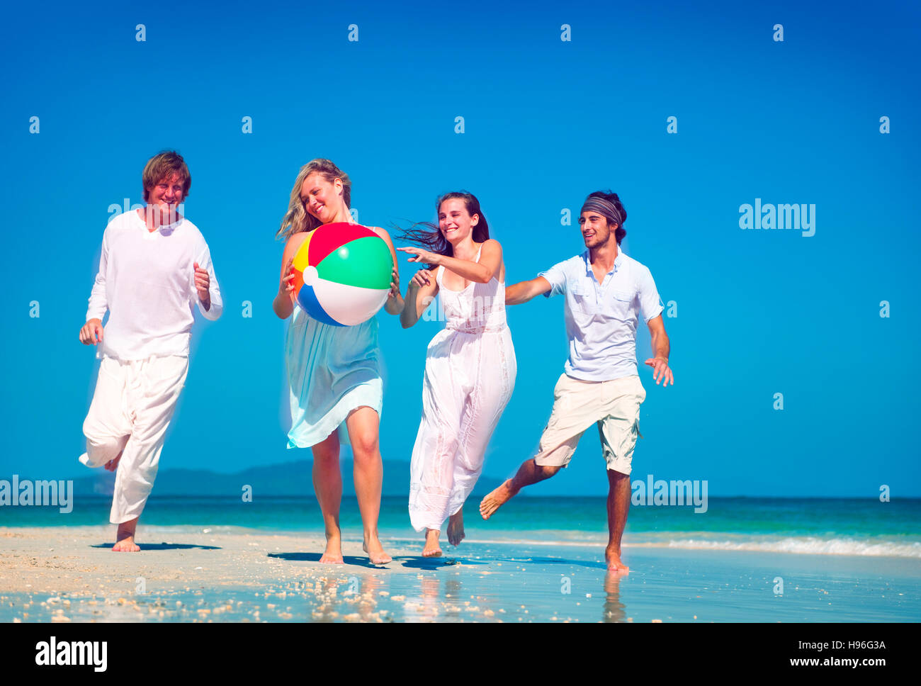 Two couple relaxing on the beach Happiness Concept Stock Photo - Alamy