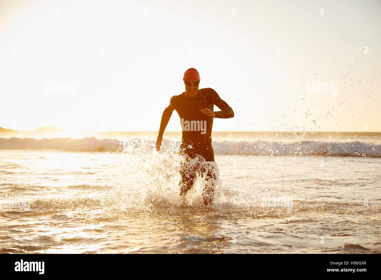 Male triathlete running out of ocean Stock Photo - Alamy