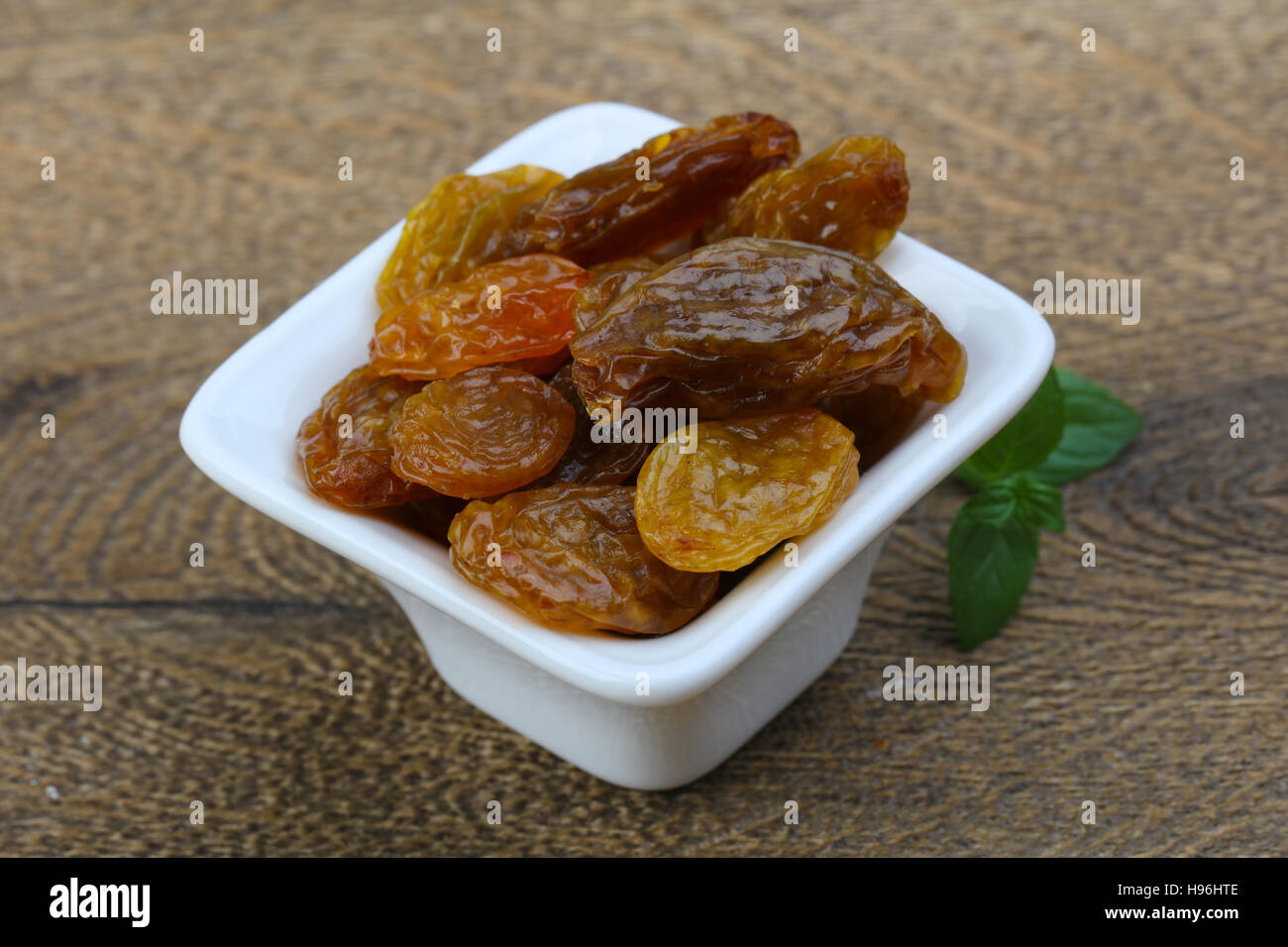 Sweet raisins in the bowl with mint leaves Stock Photo - Alamy