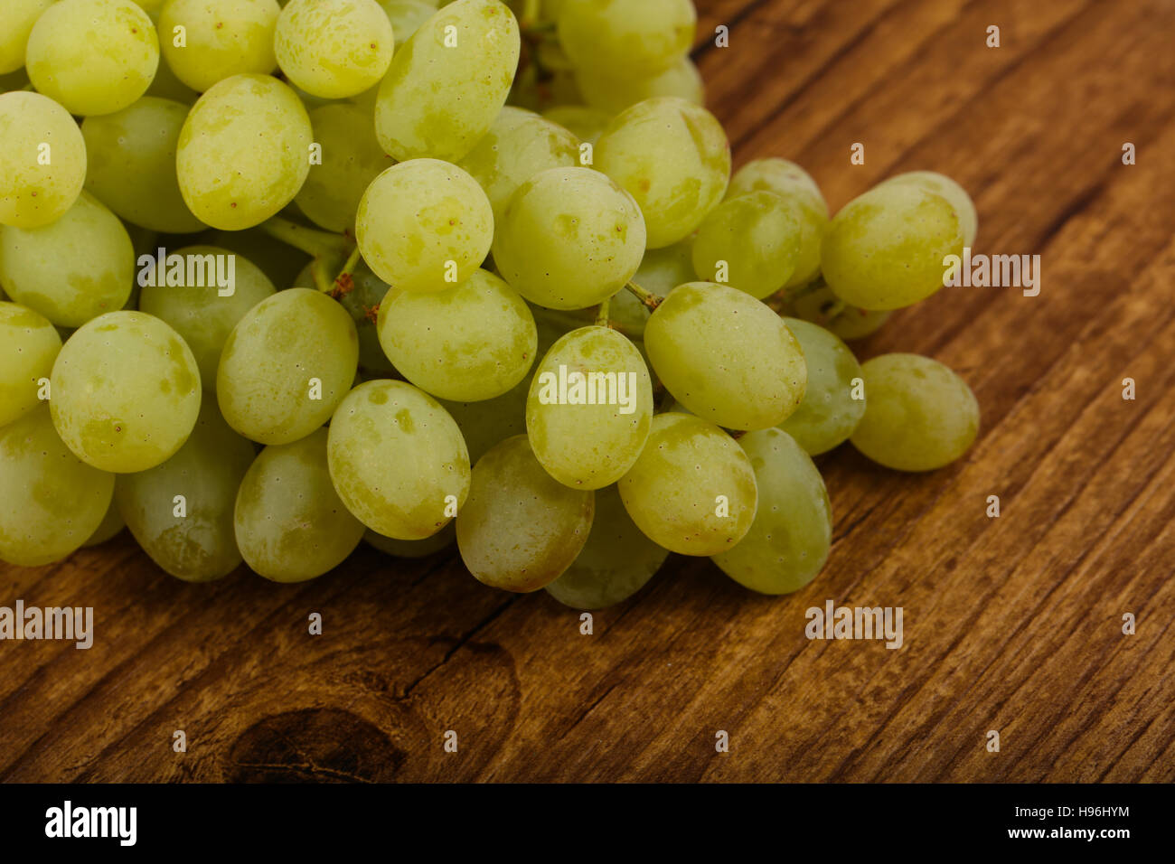 Sweet yellow grape heap on the wood background Stock Photo - Alamy