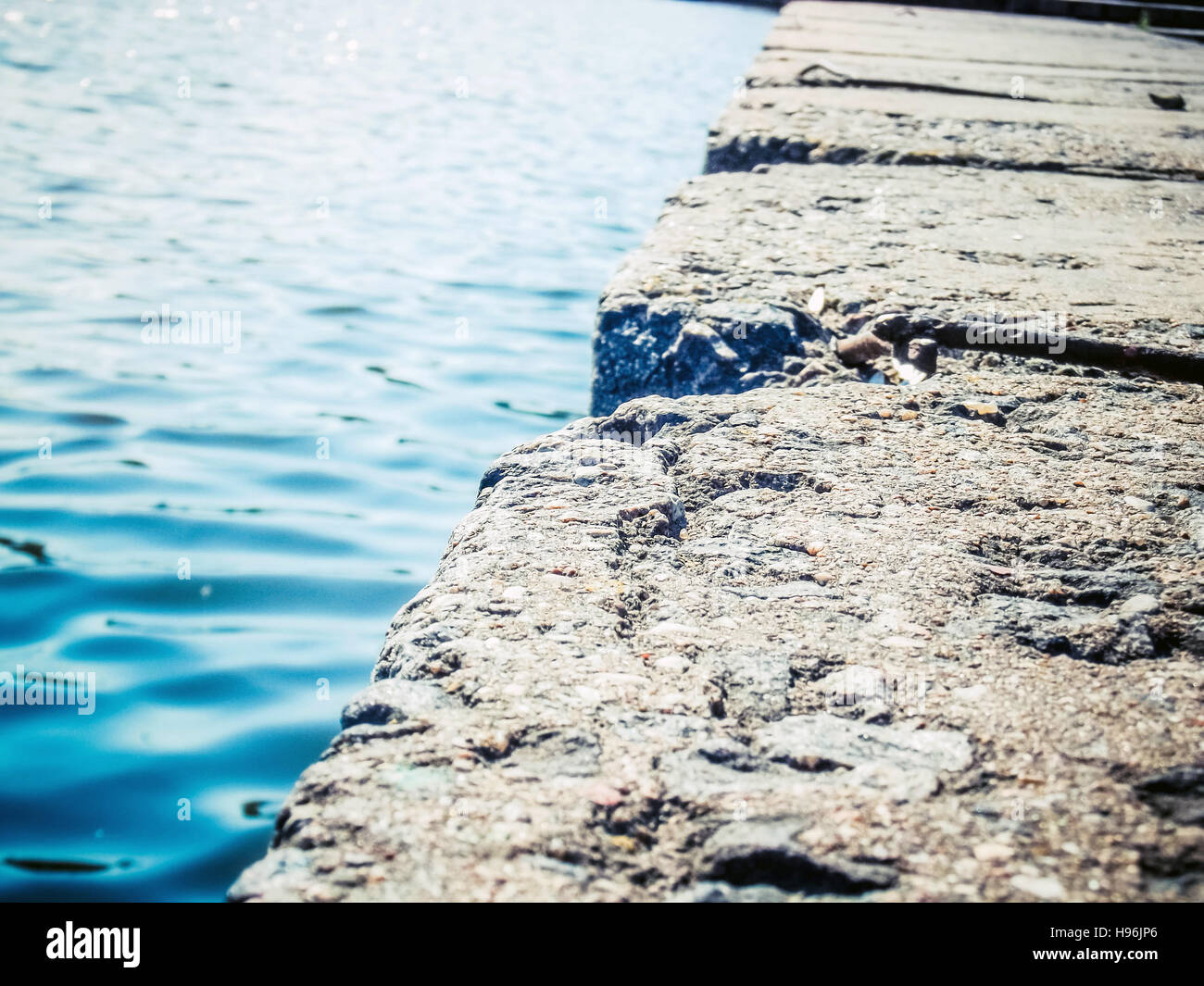 Phoro of stone slabs near the water in focus Stock Photo - Alamy