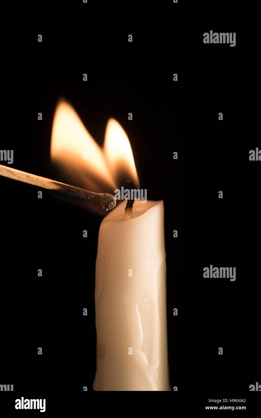 Studio shot of burning match igniting candle Stock Photo - Alamy