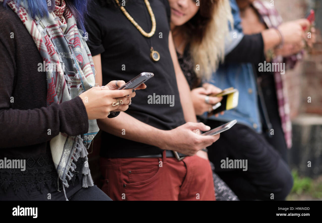 Young people standing in row using smartphones Stock Photo - Alamy