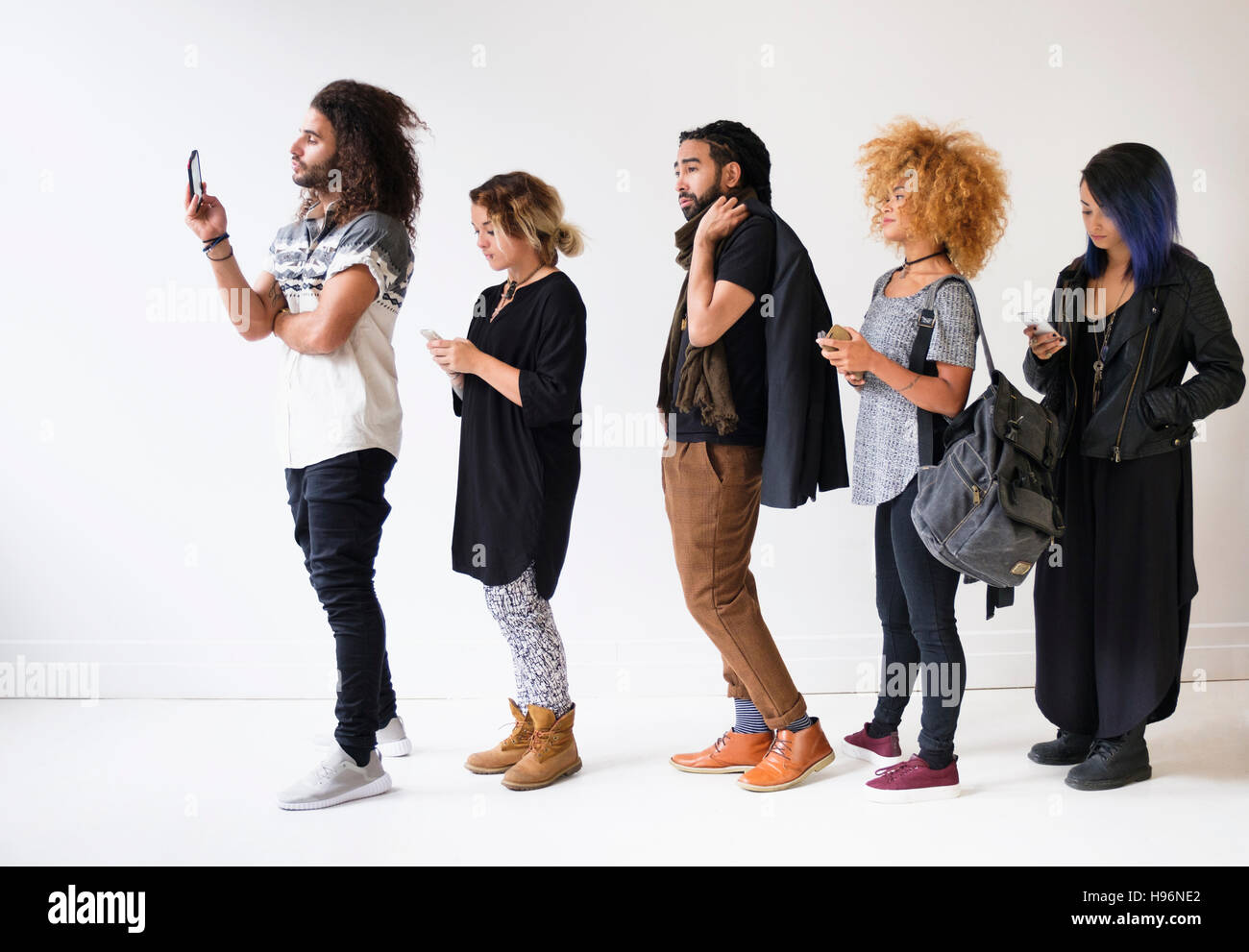Young people standing in line using smartphones Stock Photo - Alamy