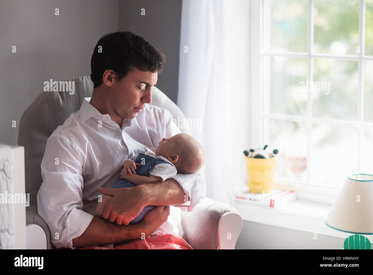 Father holding baby son (0-1 months) by window Stock Photo - Alamy