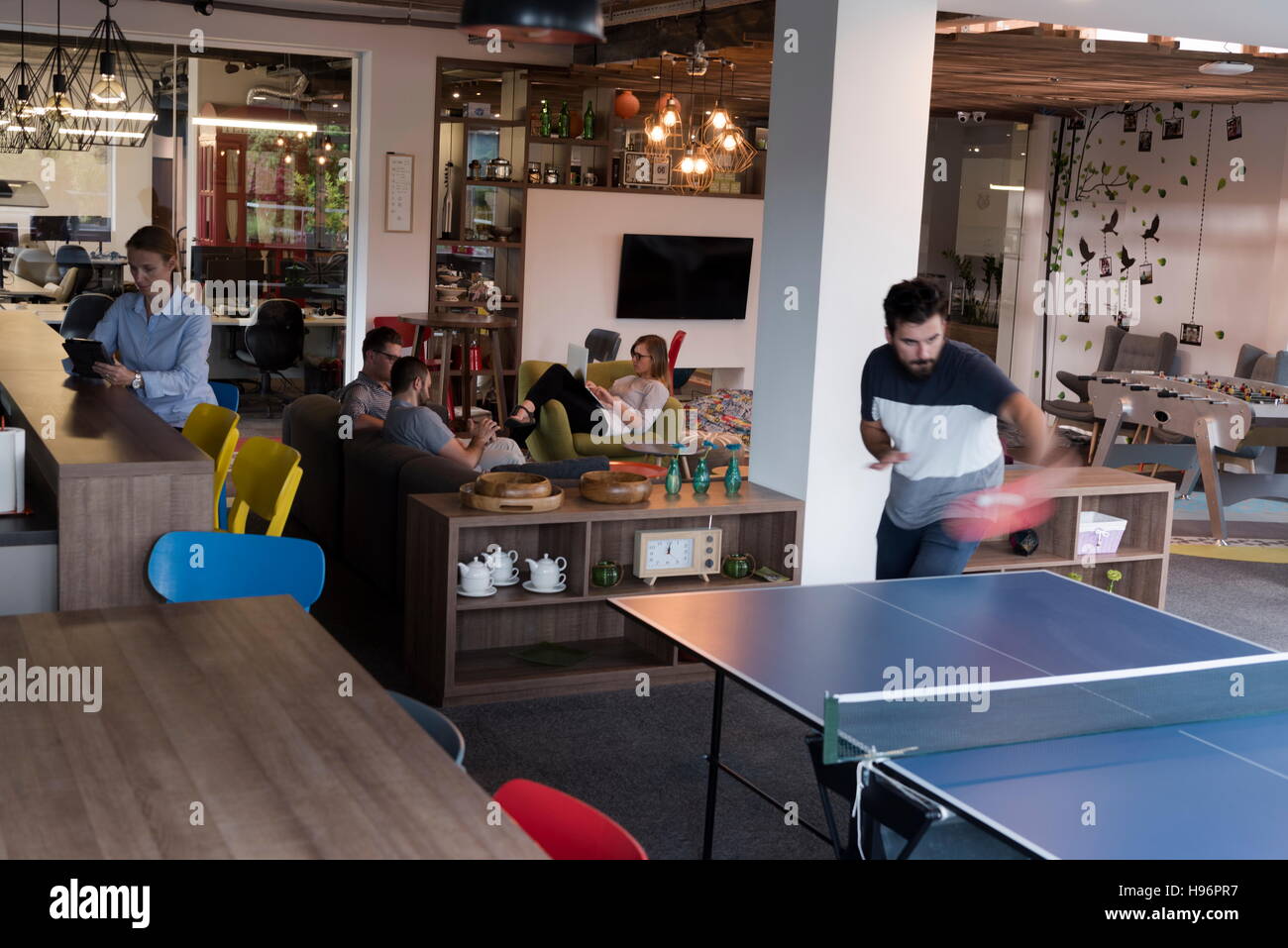 Two young start up business man playing ping pong tennis at modern ...