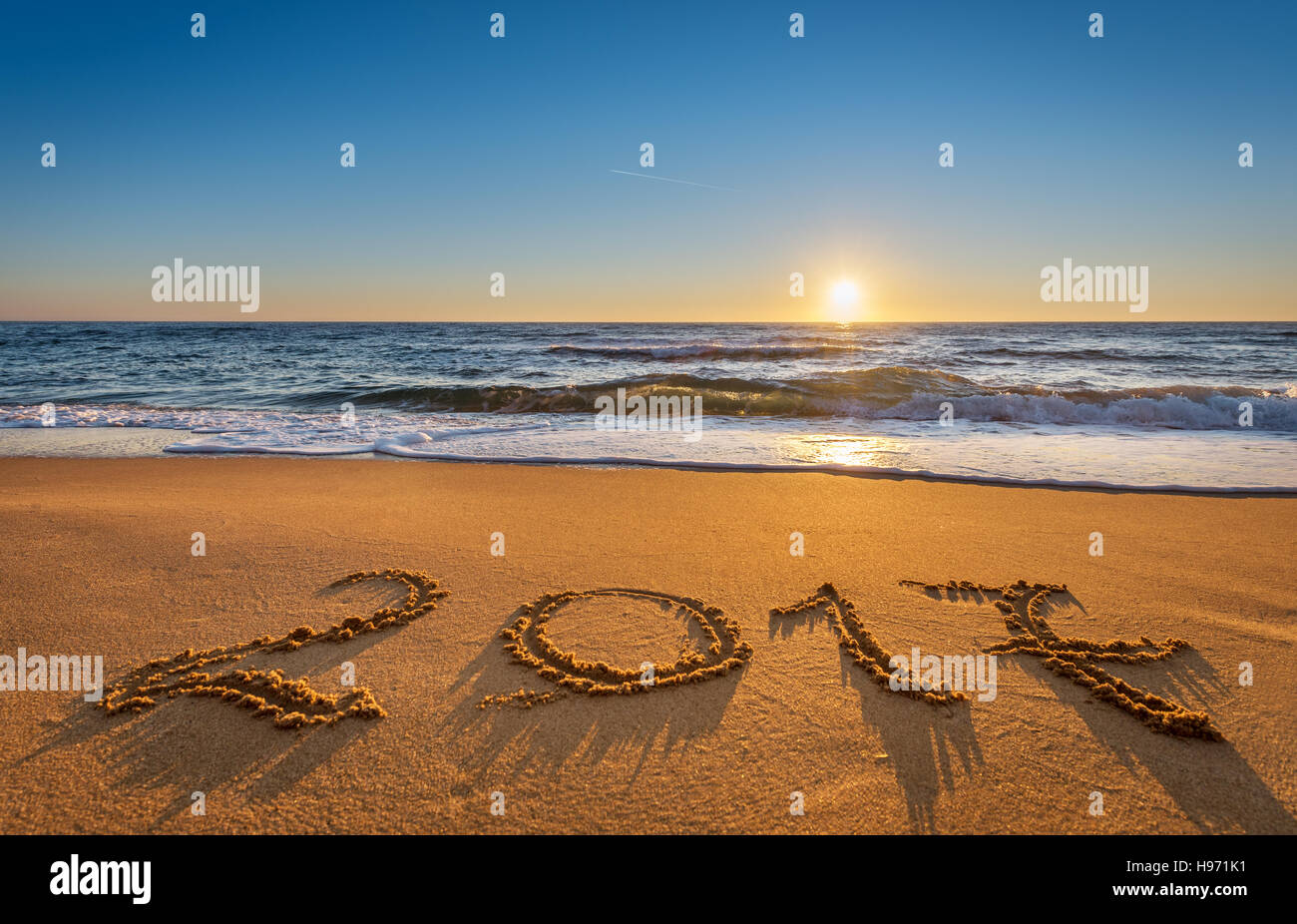 Number 2017 written on seashore sand at sunrise. Concept of upcoming ...