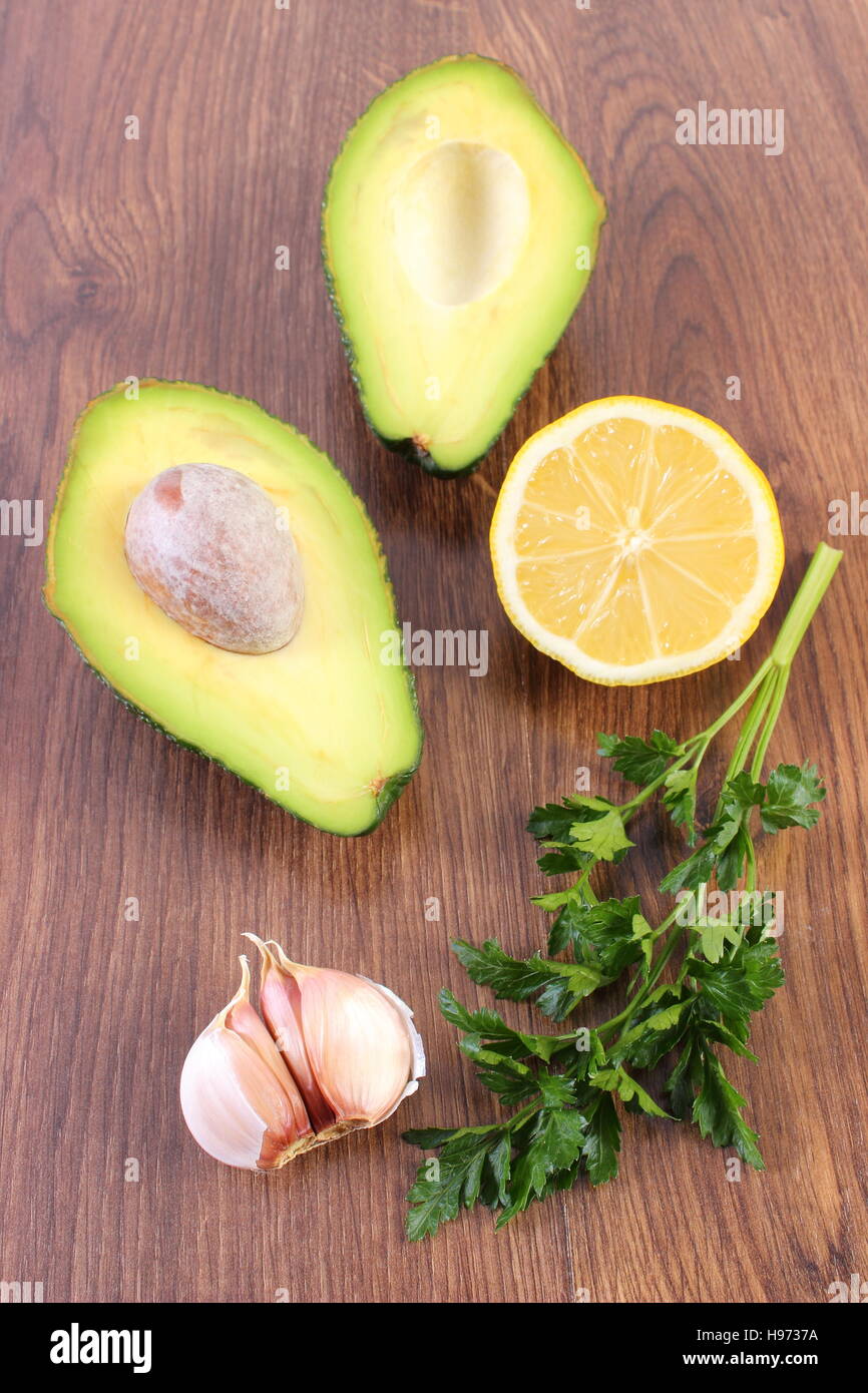 Portion of avocado, clove garlic, lemon and parsley, concept of healthy ...
