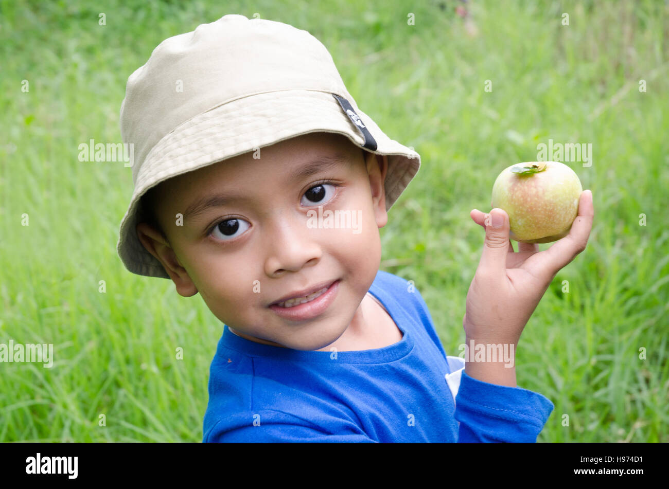 a kid with an apple, after picking apple at plantation area, in Malang ...