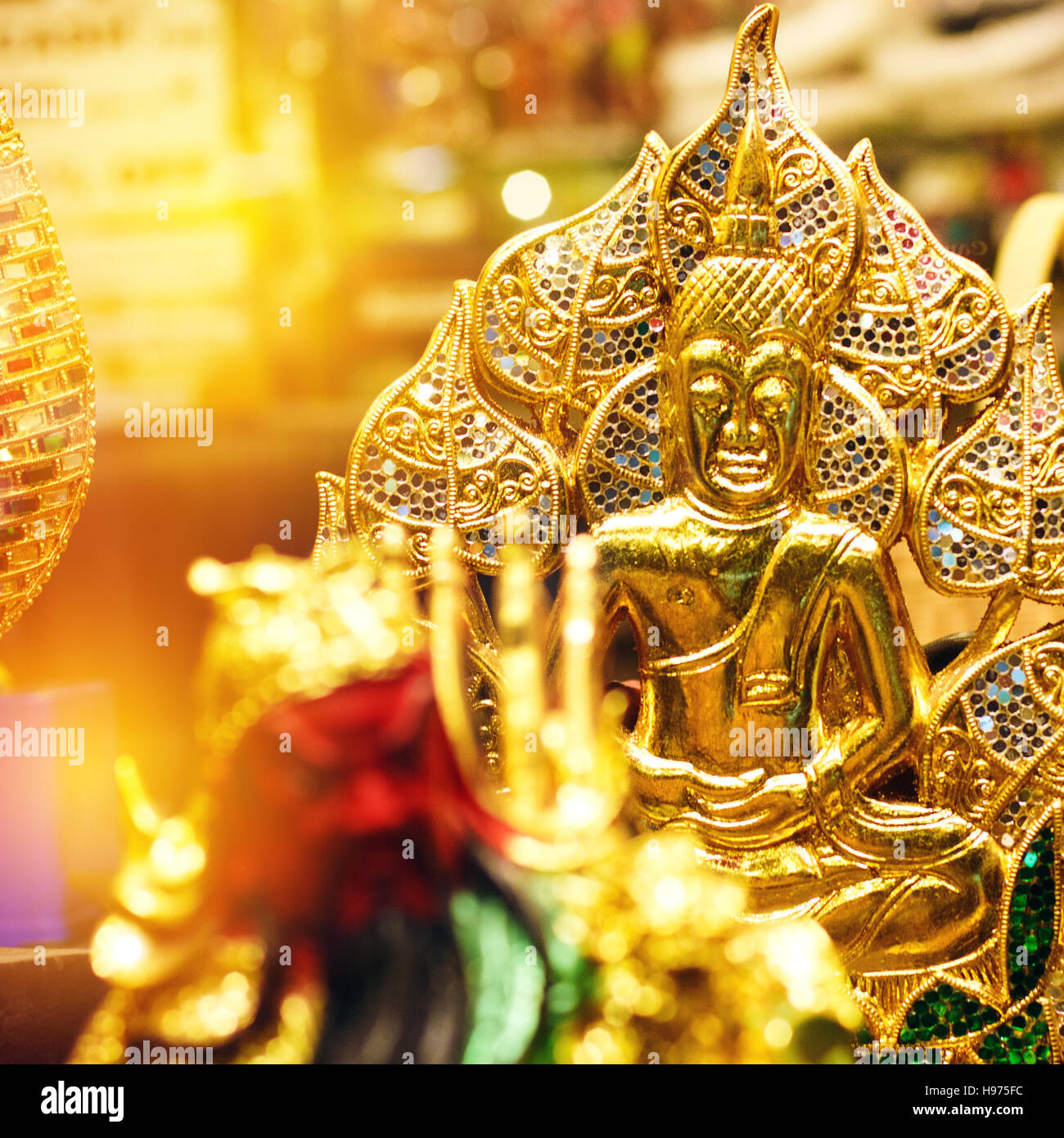Souvenir showcase with golden statue of asian god Stock Photo - Alamy