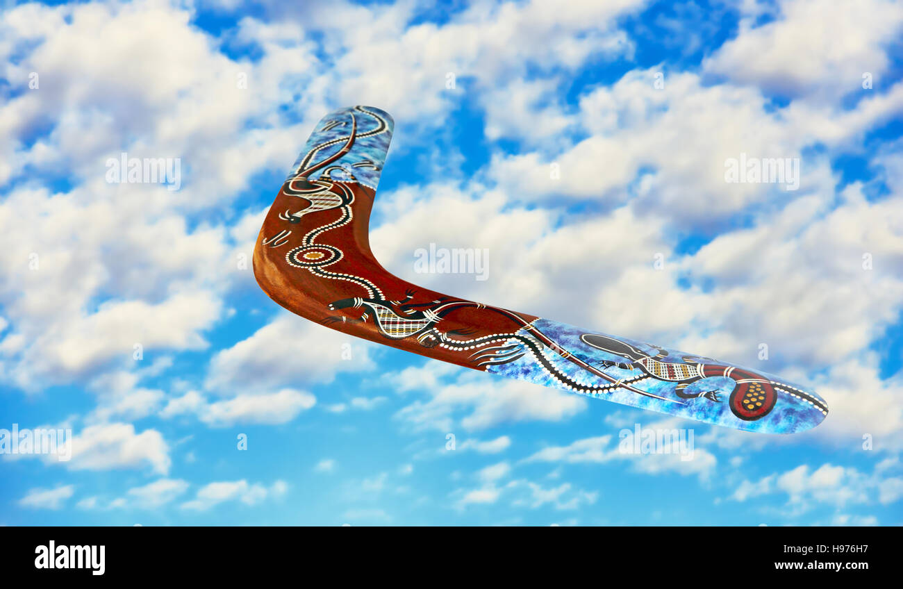 Multicolored australian boomerang in flight against of blue sky and ...