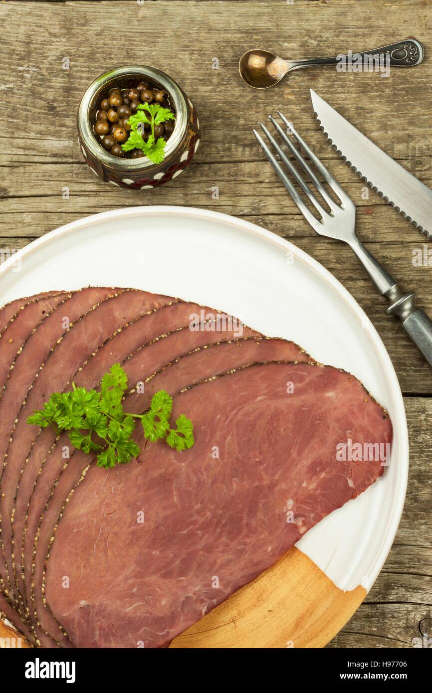Cold roast beef on a wooden table. Delicacy of beef. Preparing cold ...