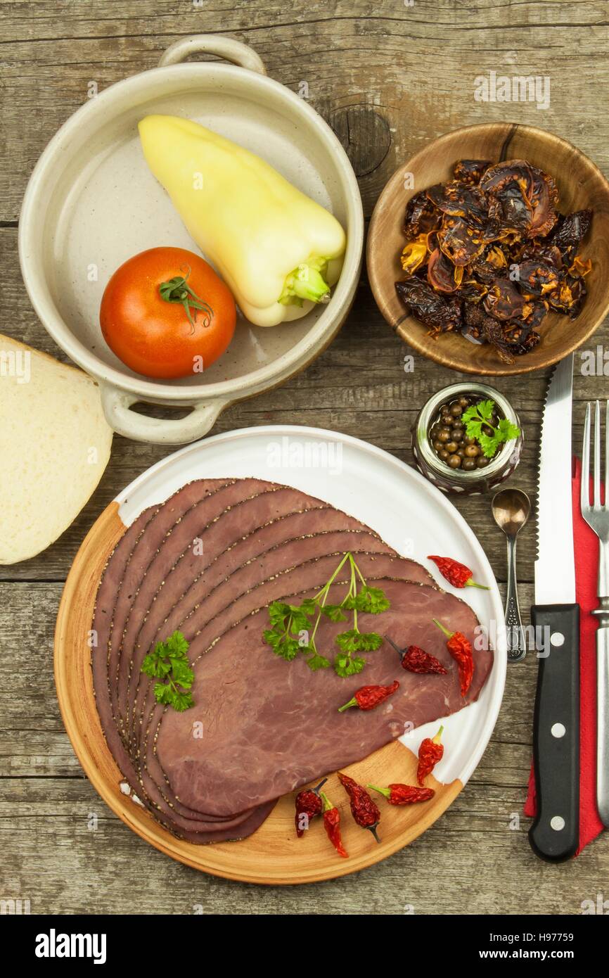 Cold roast beef on a wooden table. Delicacy of beef. Preparing cold ...