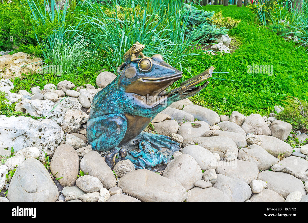 The bronze sculpture of frogs with a book next to the pond in Central ...