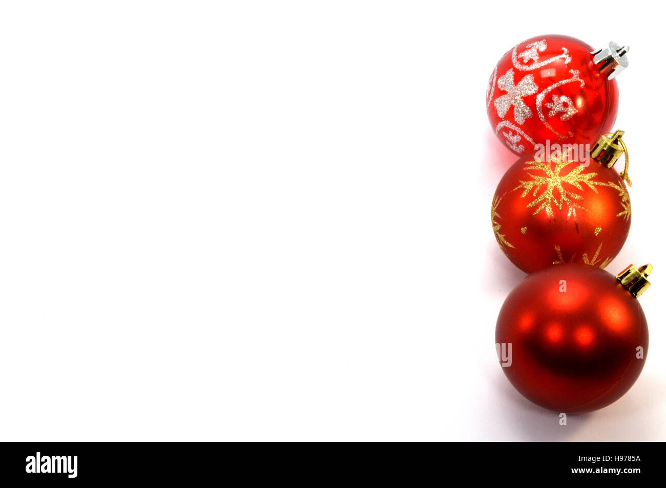 Three red christmas balls set vertically to the right on a white ...