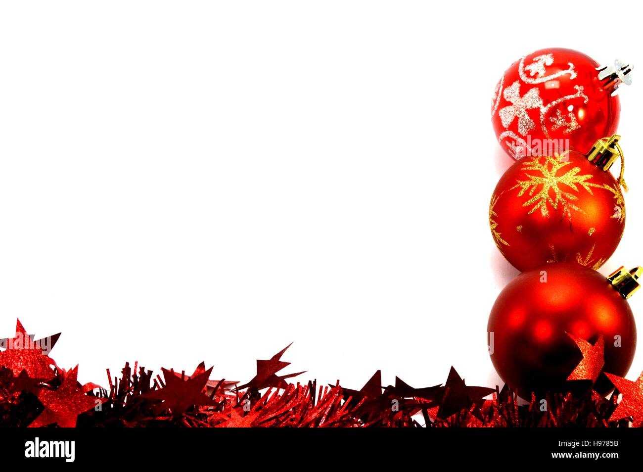 Three christmas balls and a red garland placing right vertically on a ...