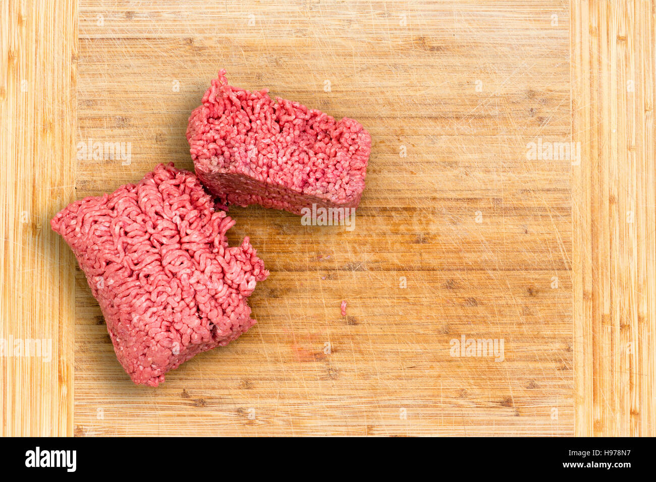 Block of fresh beef mince sliced through on a wooden cutting board with ...
