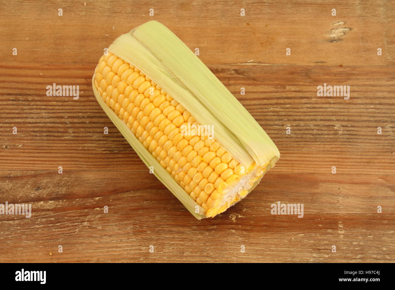 Corn on the cob isolated on a wooden surface image in landscape format ...