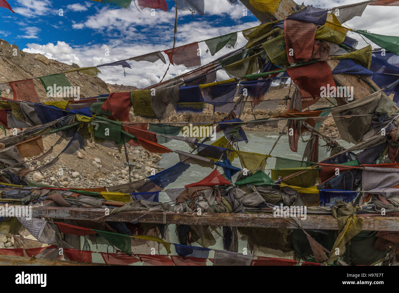 Hundreds of prayer flags adourning the structure of an old bridge on ...
