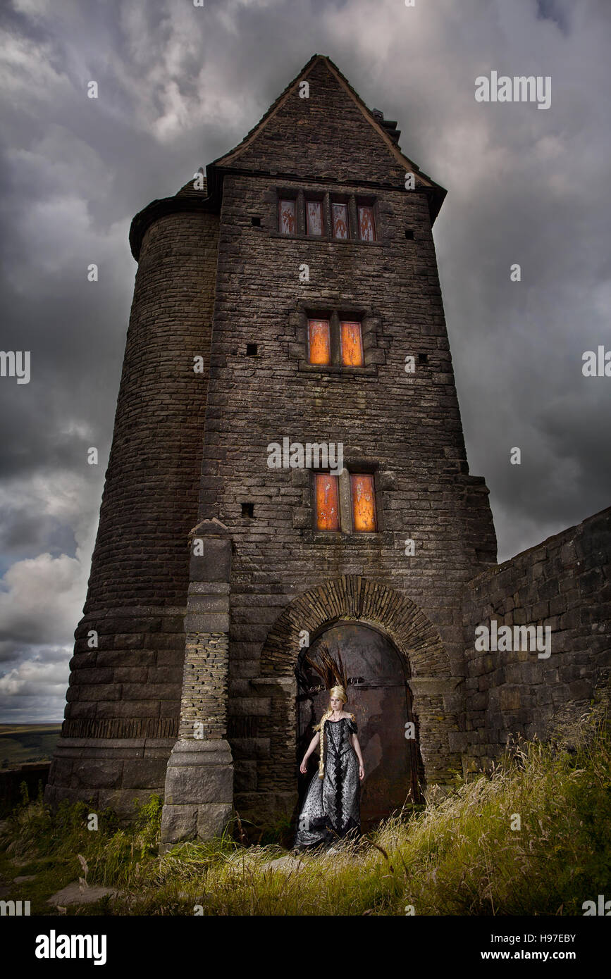 Gothic Princess standing before a medieval tower with moody skies Stock ...