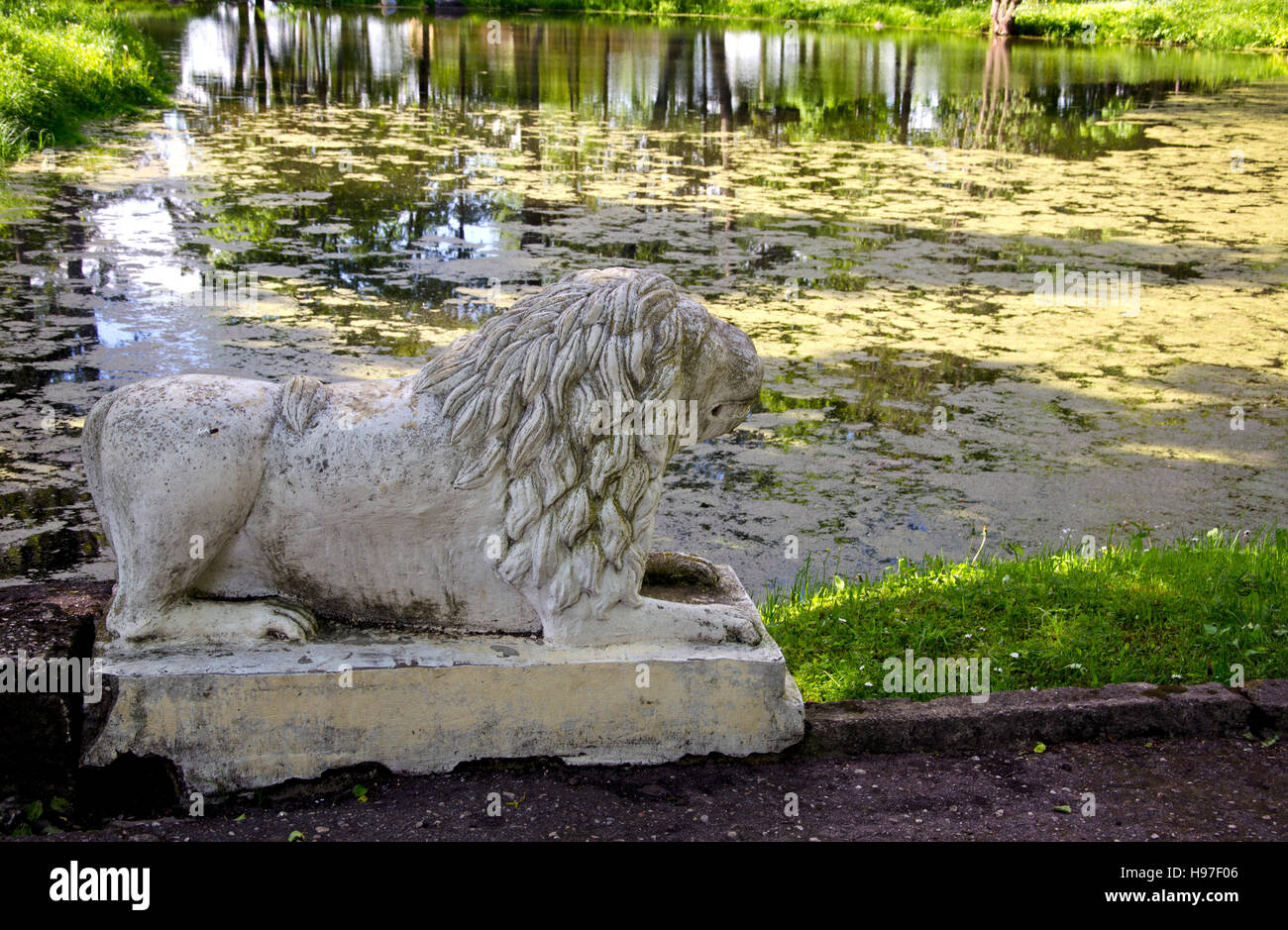 Ancient lion sculpture near old pond in manor park Stock Photo - Alamy