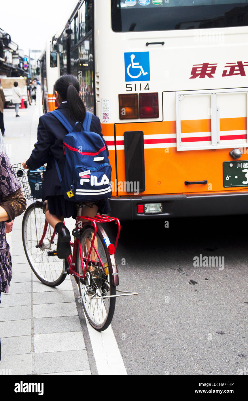 Japanese student girl riding bicycle go back home after finished class ...