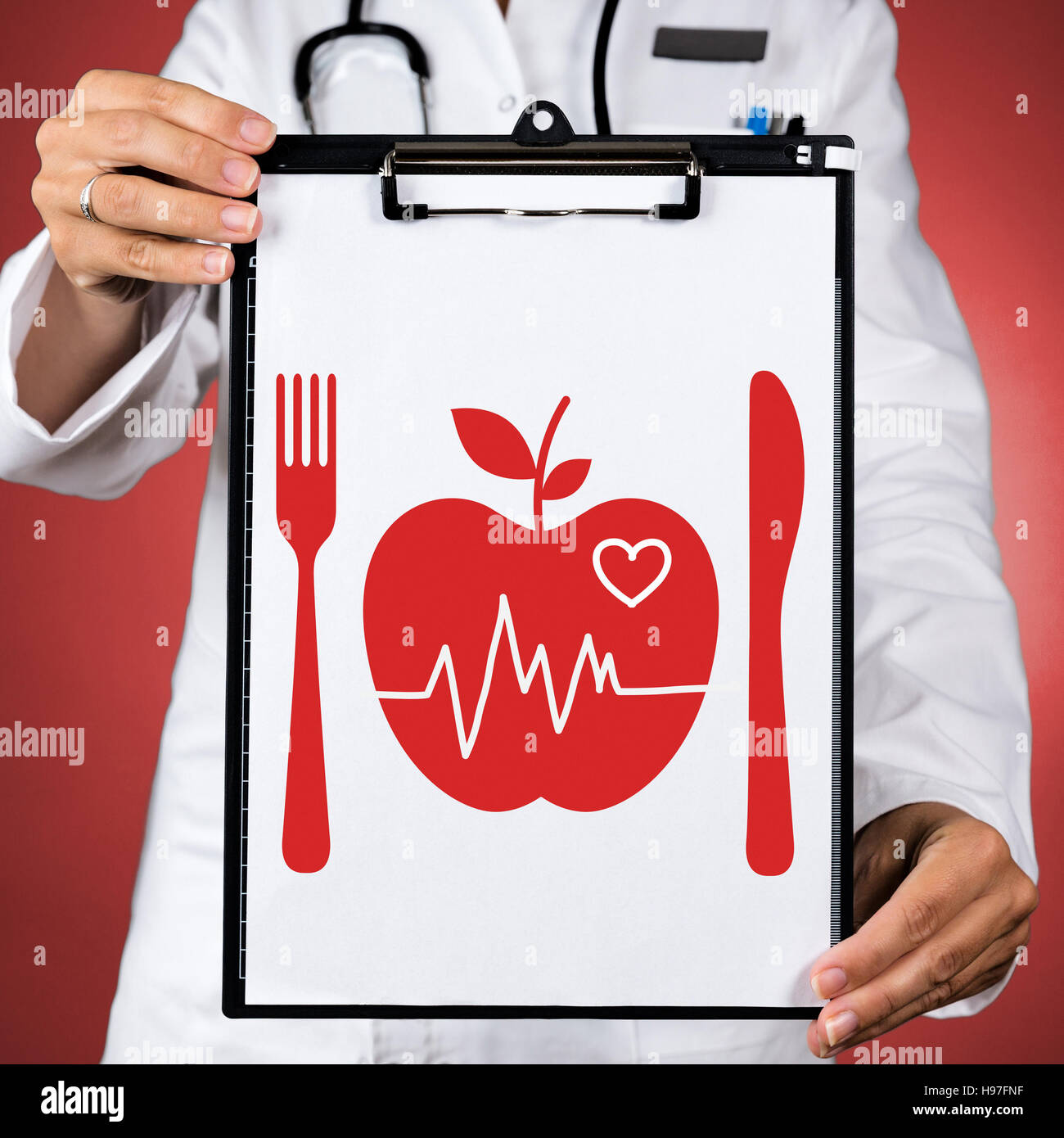 Healthy life concept. Young female doctor holding board with drawing of ...