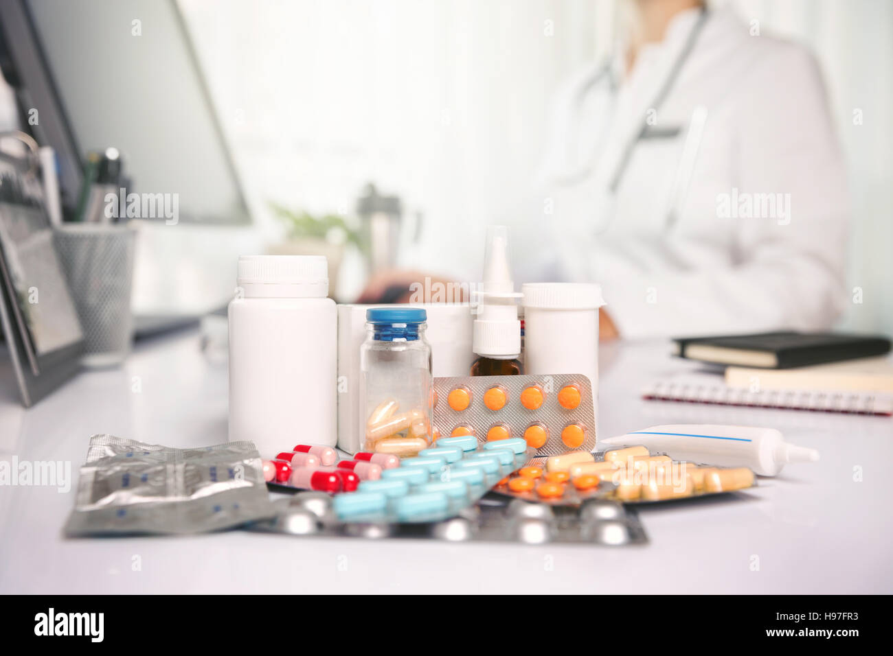 Various colorful medicines on top of the table, with female doctor ...