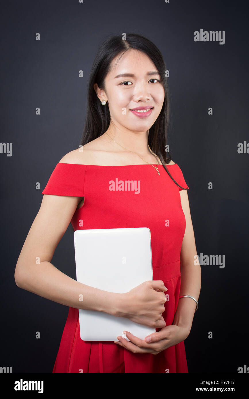 Beautiful Asian woman holding a laptop computer Stock Photo - Alamy