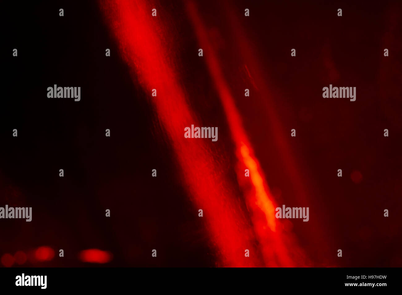 Polygonal red colored light beams in center of solid black background ...