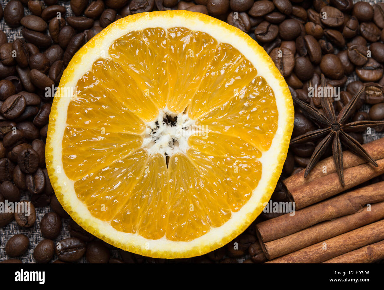 slice juicy orange among coffee beans Stock Photo - Alamy