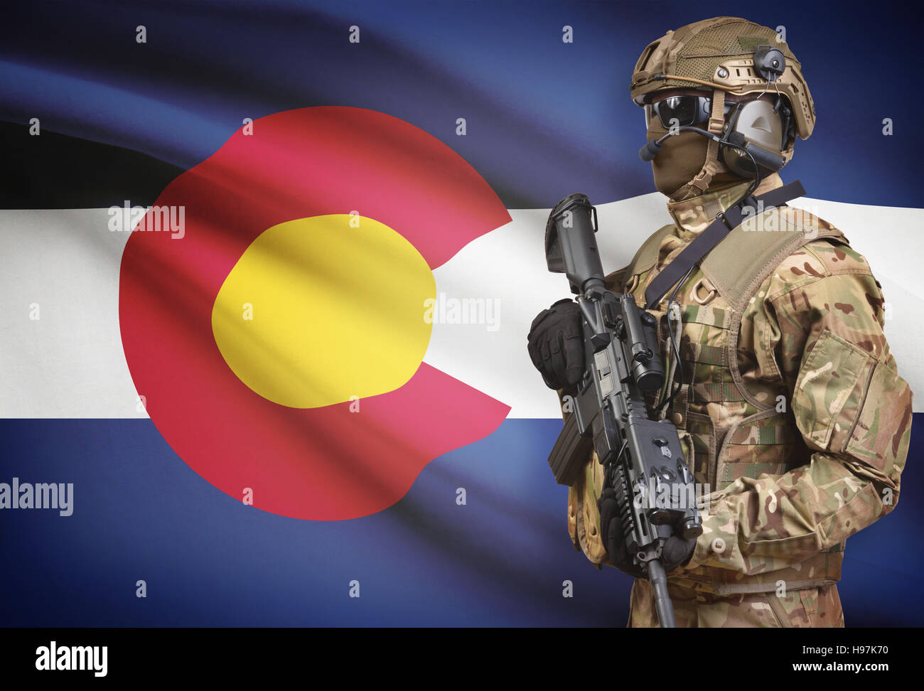 Soldier in helmet holding machine gun with USA state flag on background ...