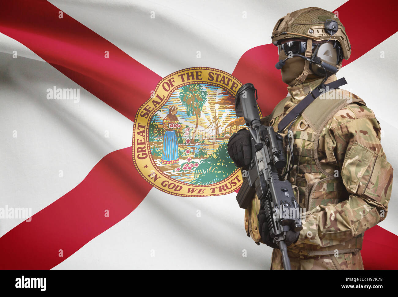 Soldier in helmet holding machine gun with USA state flag on background ...