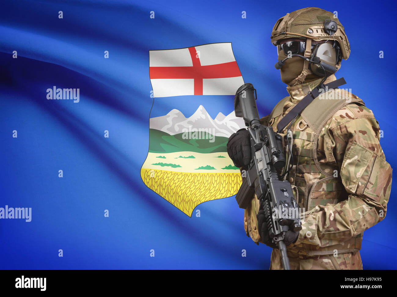 Soldier in helmet holding machine gun with Canadian province flag on ...