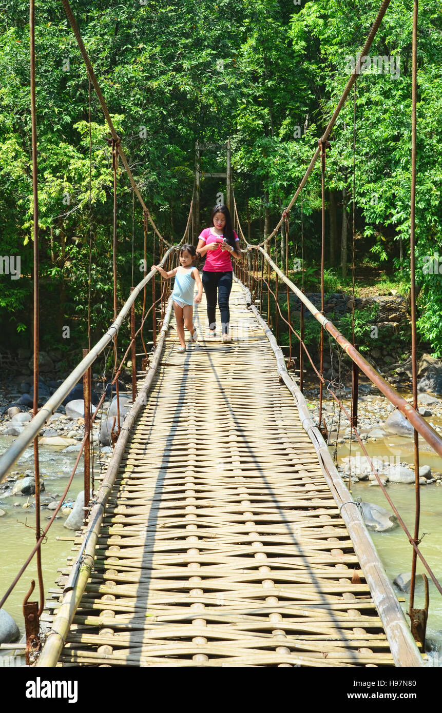 Two girls walking across an old suspension bridge Stock Photo - Alamy